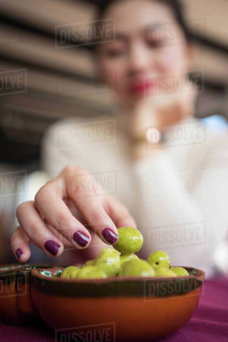 Asian woman eating olives in restaurant - Royalty-free Stock Photo ...