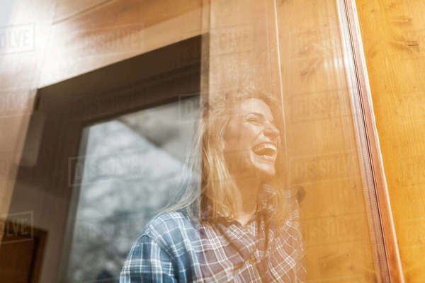 Beautiful and young woman reflection in a windows of her house and ...