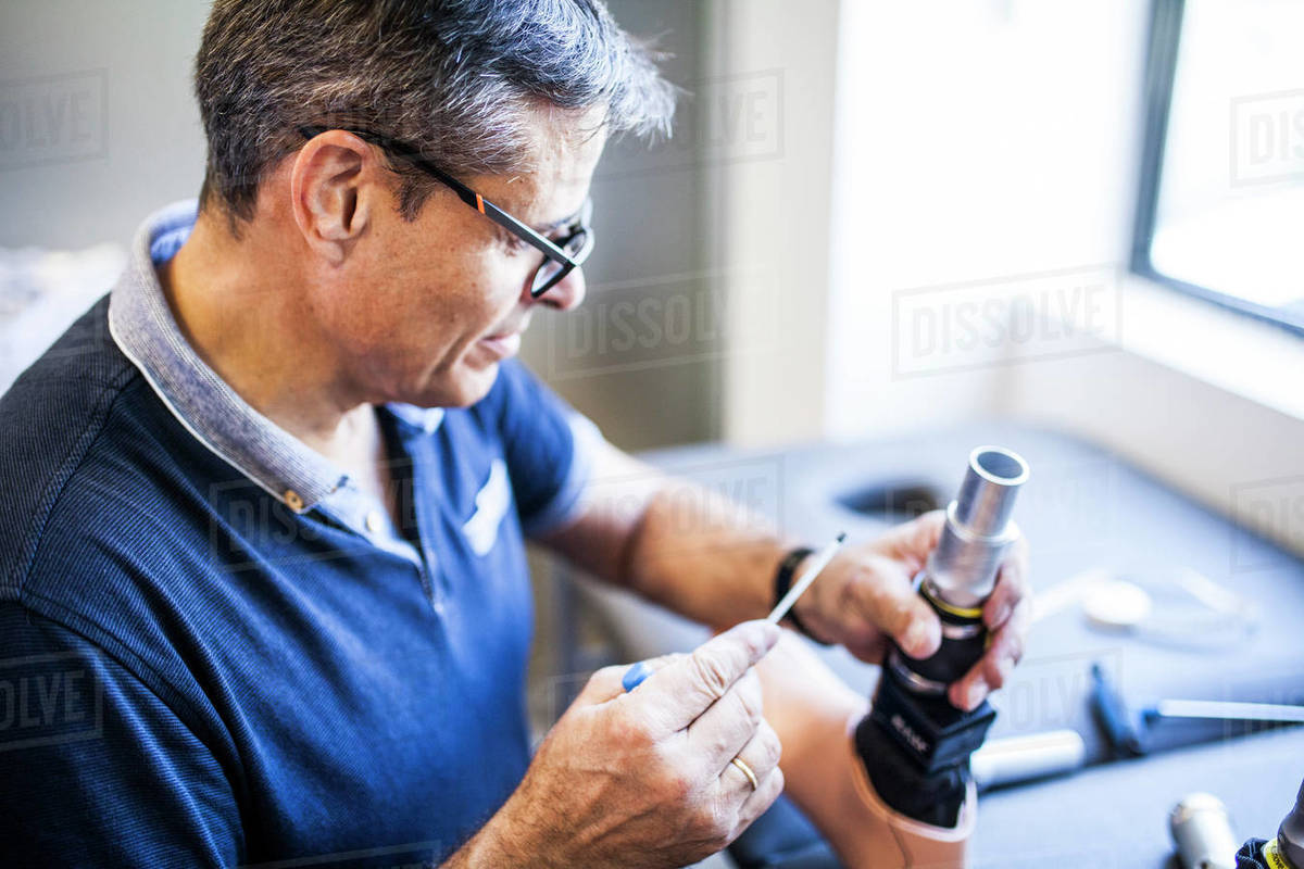 Prosthetic engineer reviewing the prosthesis of a patient and improving ...