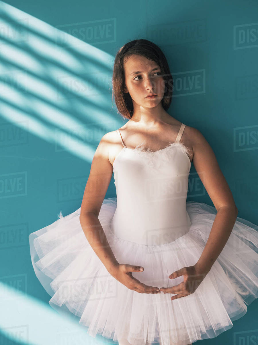 Ballerina standing with sad face near wall - Stock Photo - Dissolve