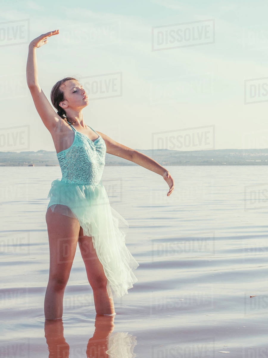 Classical ballet position gracefully performing by ballerina with ...