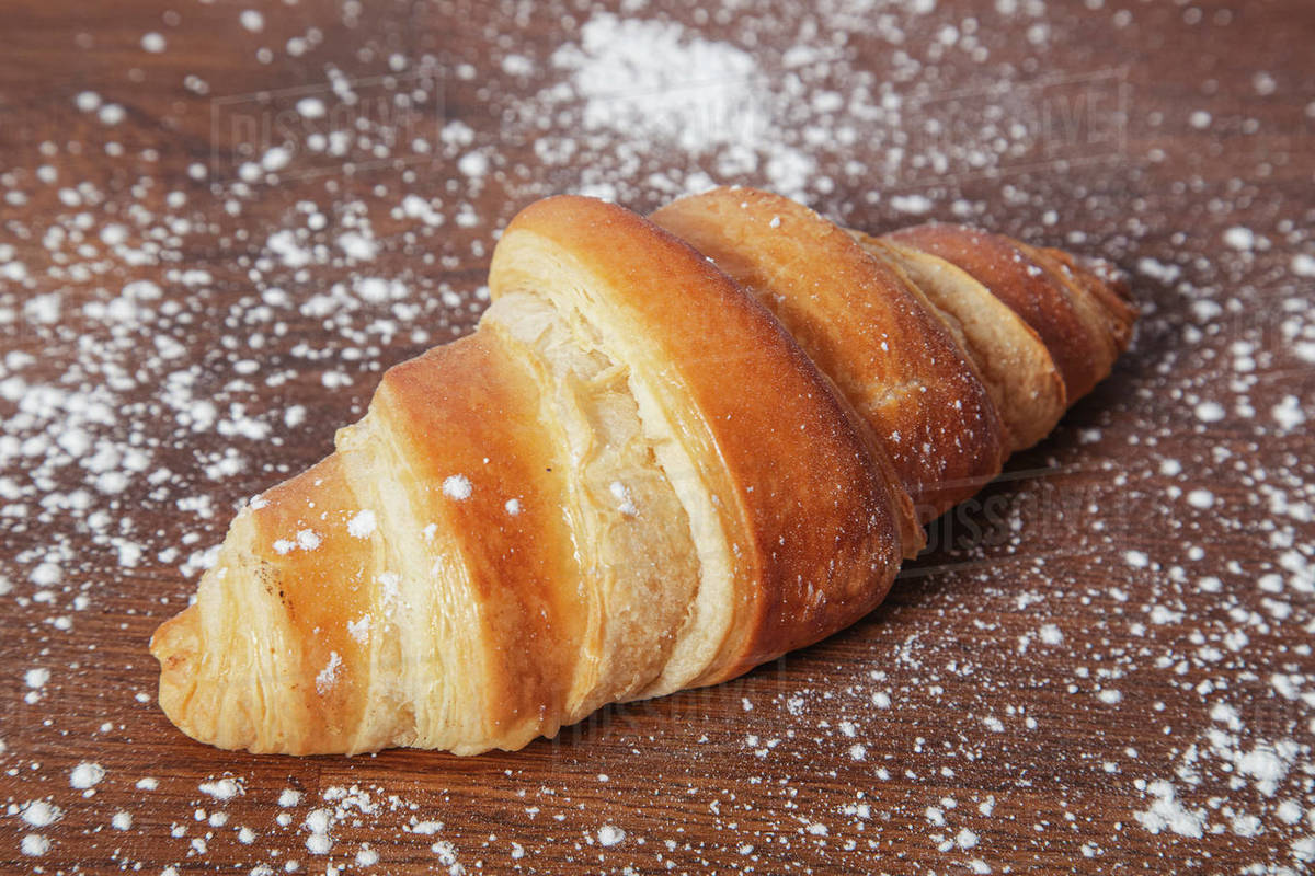 From above of delicious baked croissant with golden crust on wooden ...