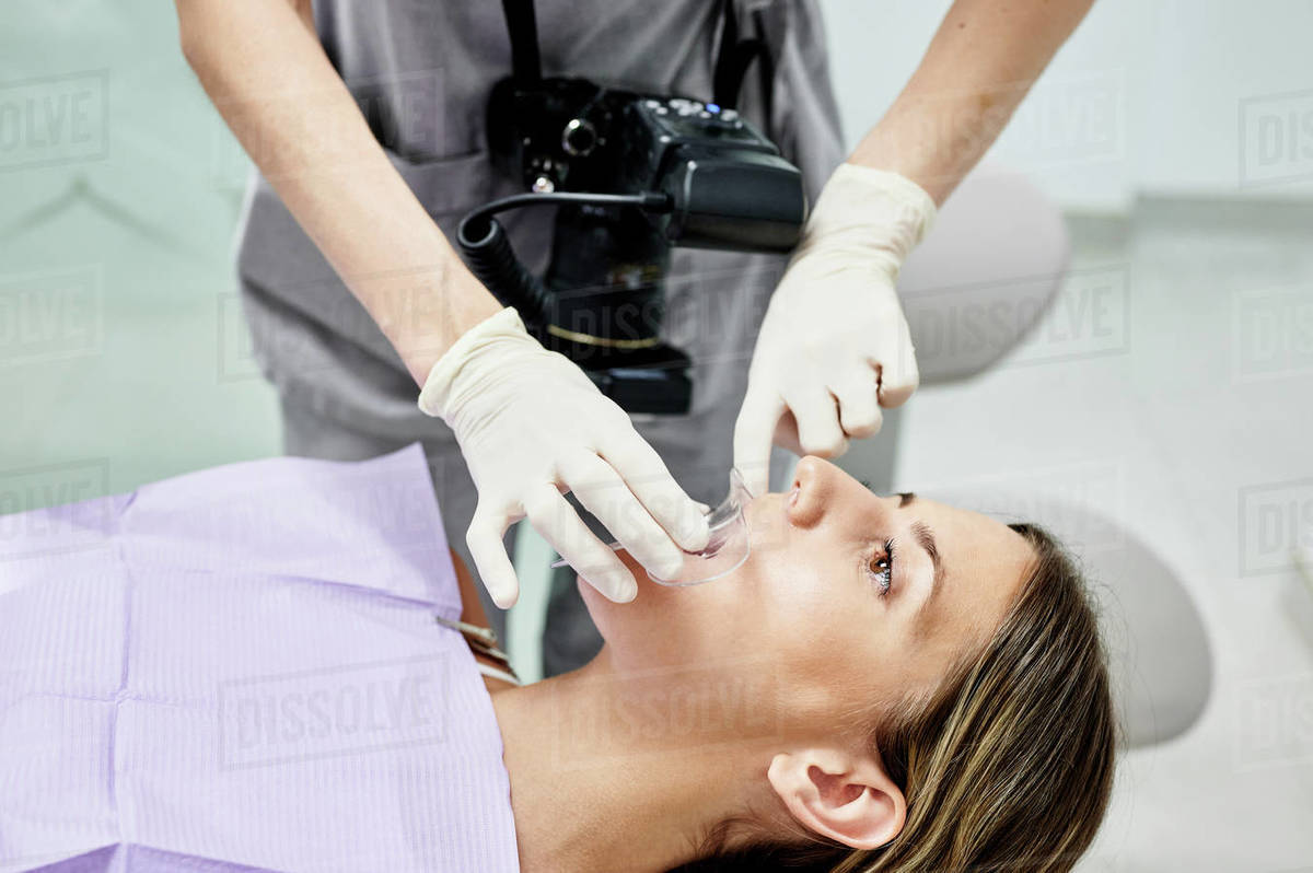 From above of crop faceless doctor placing dental retractor in mouth of ...