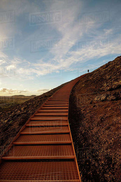 Footpath with metal steps leading up to mountain on background of ...