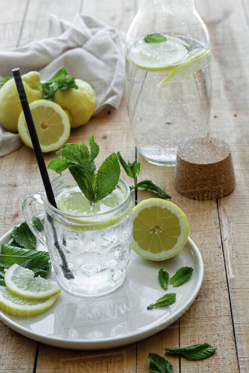Cold refreshing drink with soda water and lemon garnished with fresh ...
