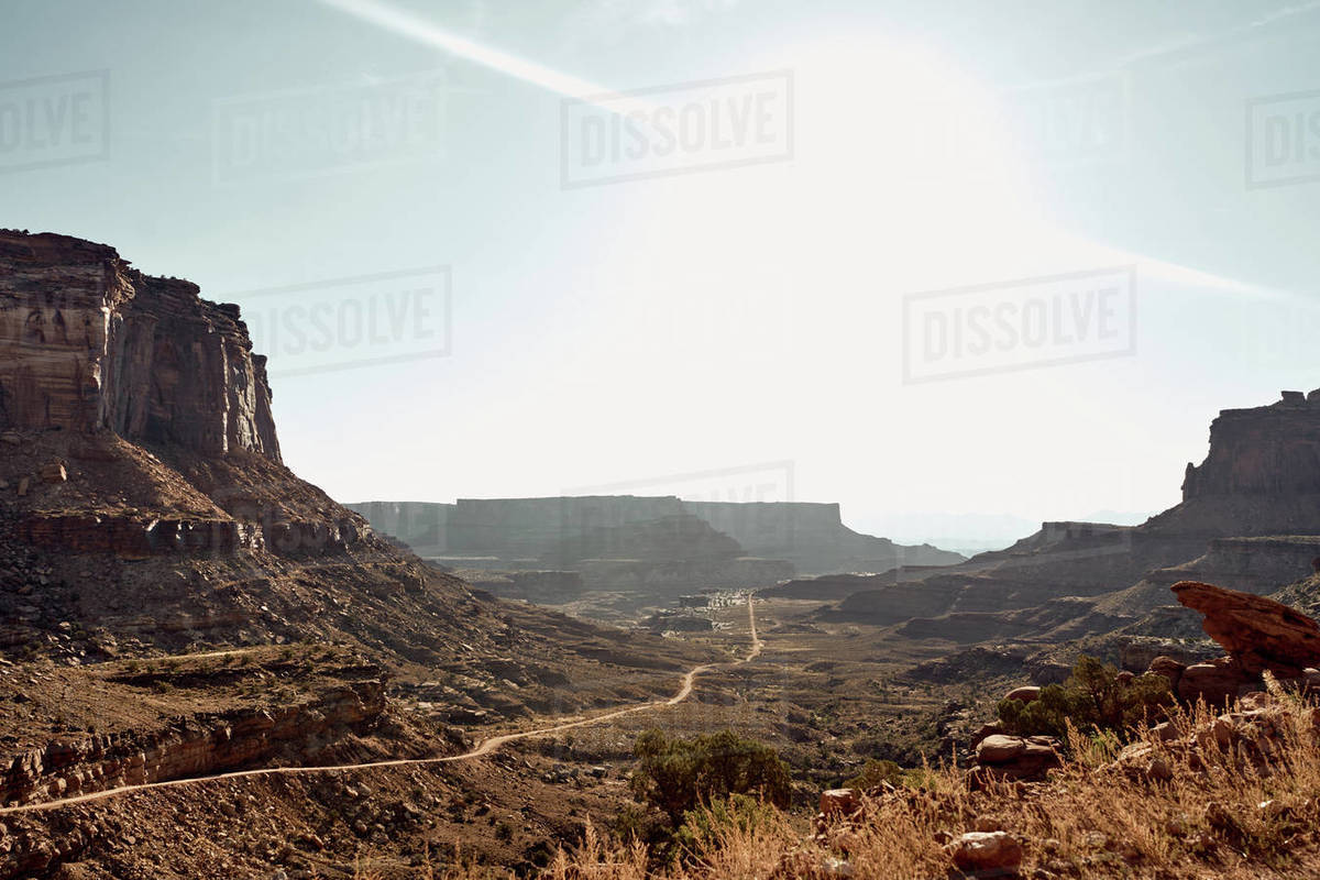 Majestic scenery of sandy road surrounded by rough mountains in ...