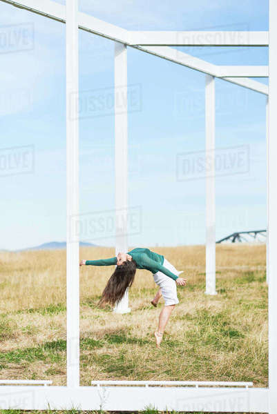 Back view of unrecognizable female bending back and falling down while ...