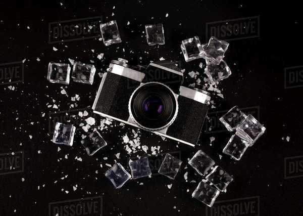 Top view of vintage photo camera surrounded by ice cubes showing ...