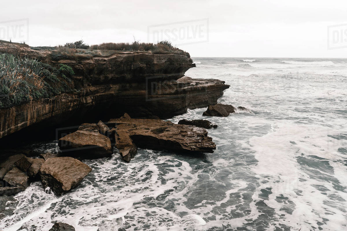 Beautiful landscape of cliffs among sea waves on cloudy day - Stock ...