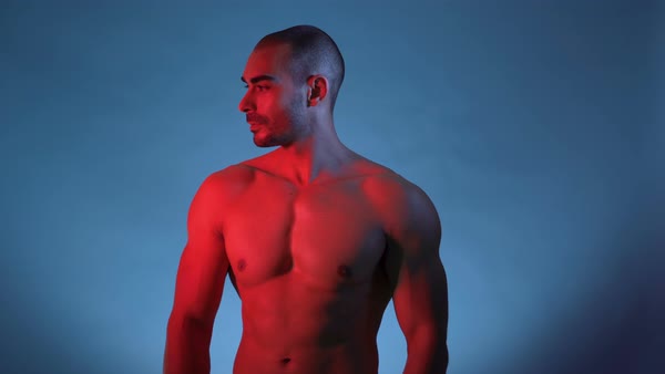 Male Fitness Model Flexing muscles, isolated on blue background. Studio ...