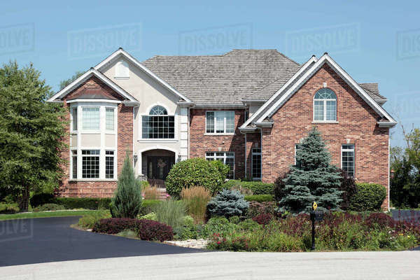 Large brick home with front landscaping - Stock Photo - Dissolve