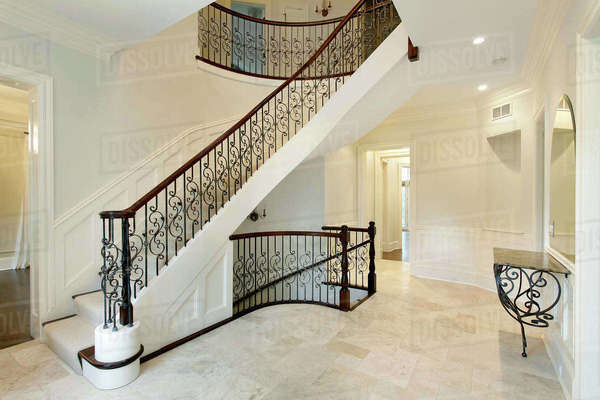 Foyer in suburban home with wrought iron staircase railing. - Royalty ...