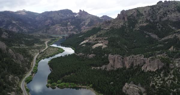Aerial drone scene flying above pure blue river at mountainous ...