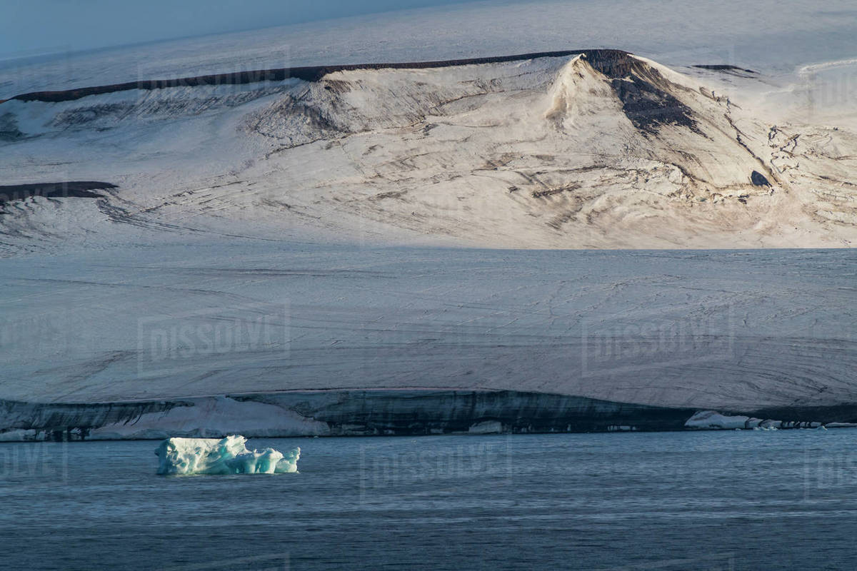Iceberg floating in front of flat table mountains covered with ice ...