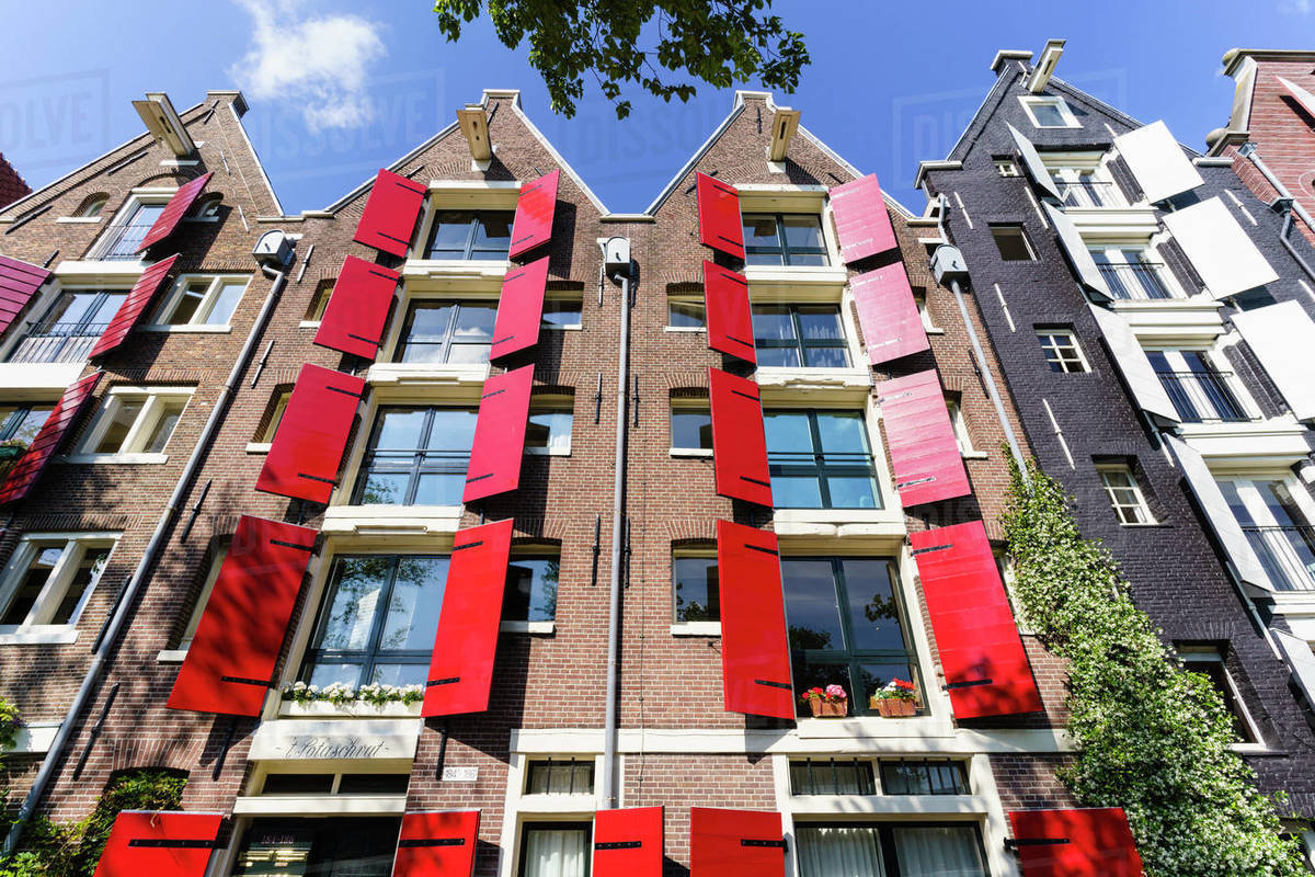 Red shutters on traditional Dutch style building, Amsterdam, North ...