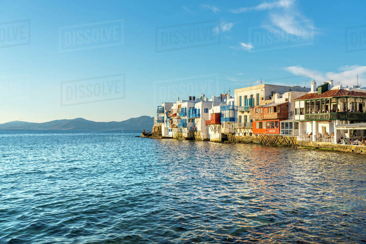 Mykonos Town at sunset with mountains in background, Mykonos, Cyclades ...