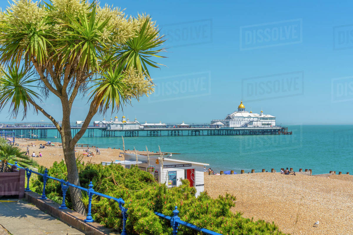 View of sea front promenade, pier and beach in summer time, Eastbourne ...