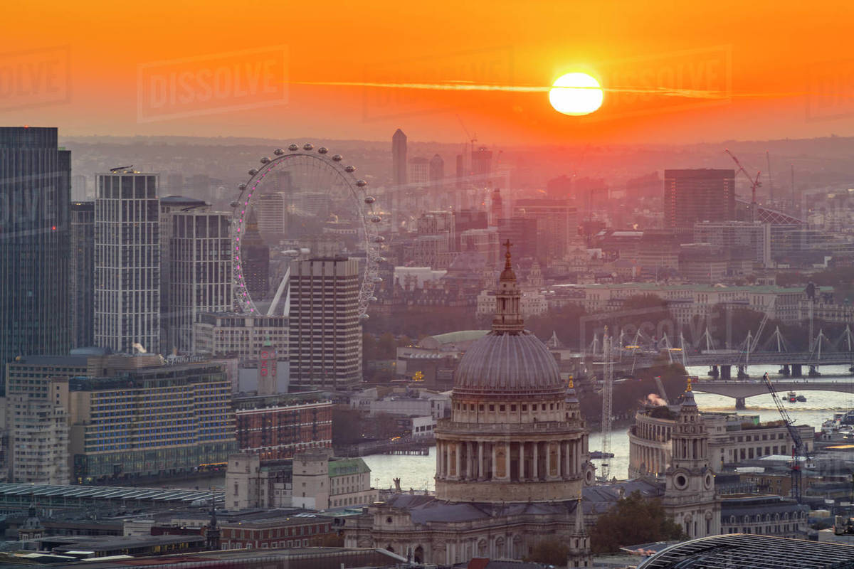 View of sun setting over London Eye and St. Paul's Cathedral from the ...
