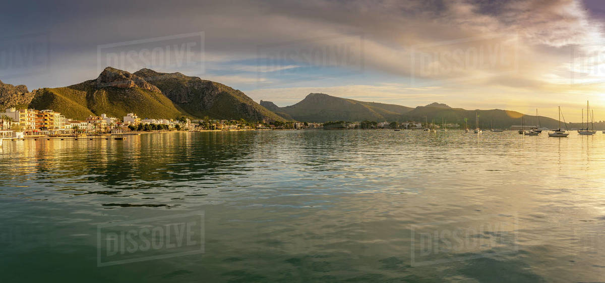 View of sunrise reflecting on hotels and bars in Port de Pollenca, Port ...