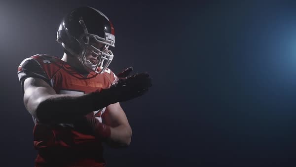 Portrait of determined professional American football player in helmet ...