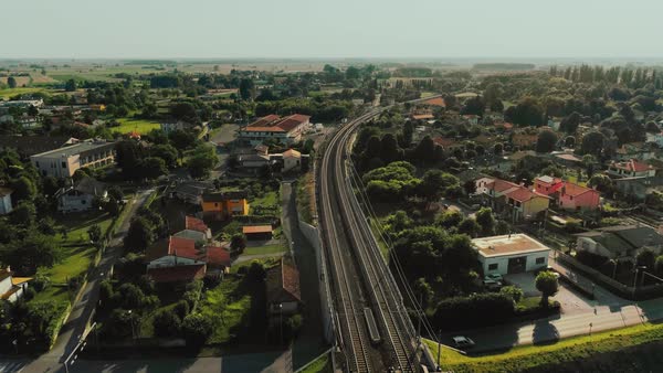 Aerial drone footage of metro or railway line go through city suburbs ...