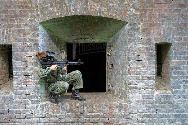 woman in uniform with a gun in military paintball training. - Royalty ...