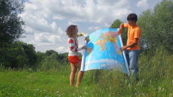 man and woman unrolling political map stands in summer park - Stock ...