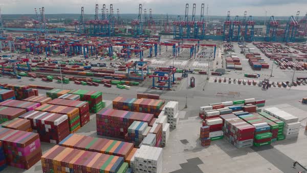 Fly above logistic terminal. Backwards reveal of river flowing along ...