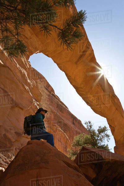 USA, Utah, Arches National Park. Lone hiker stands under Wall Arch one ...