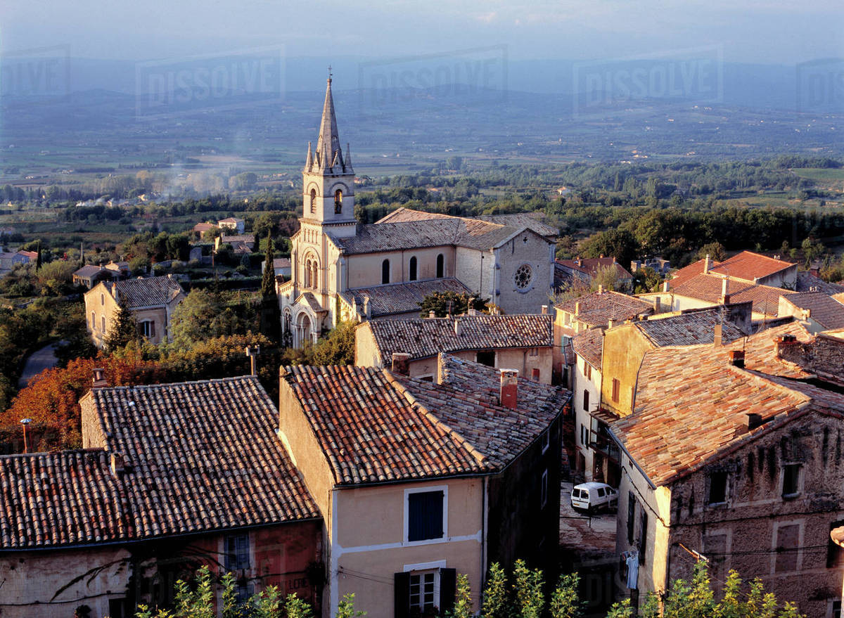Europe, France, Bonnieux. Sunset light falls on the tile roofs of ...