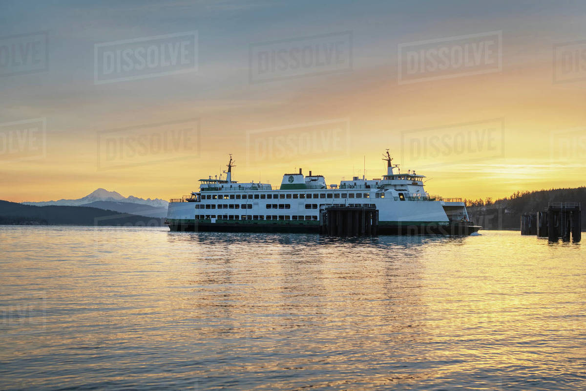 San Juan Islands Ferry approaching dock at sunrise in Guemes Channel ...