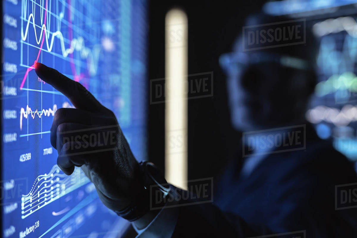 The old businessman working on the big blue screen with graphics ...