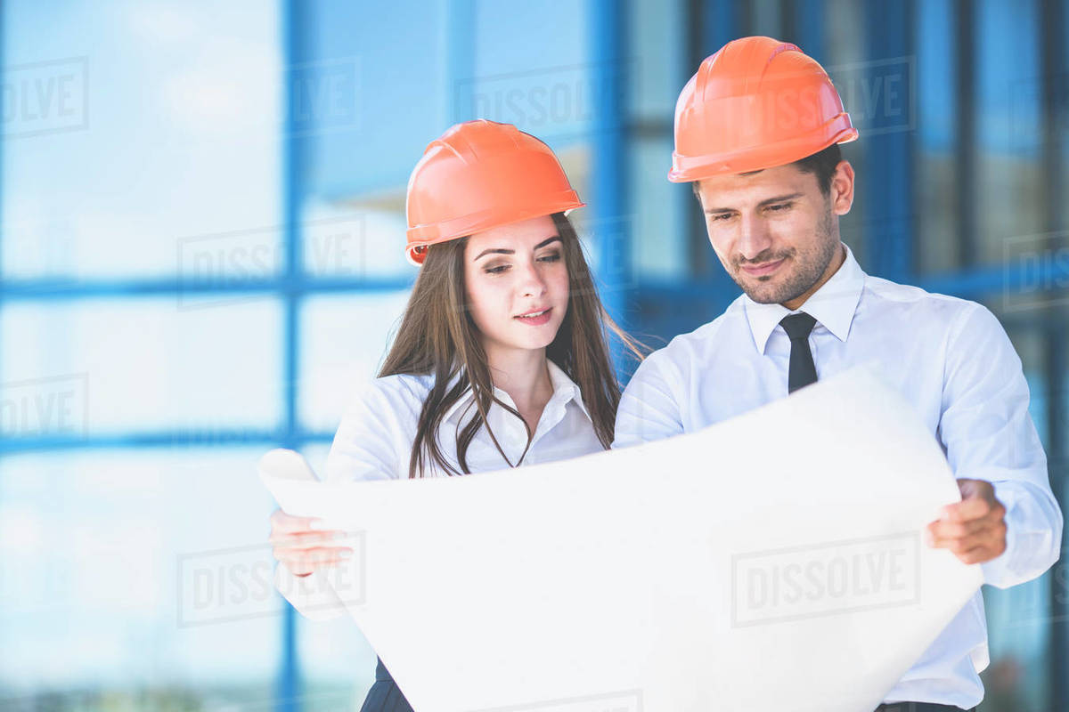 The two engineers look to the project plan on the background of the ...