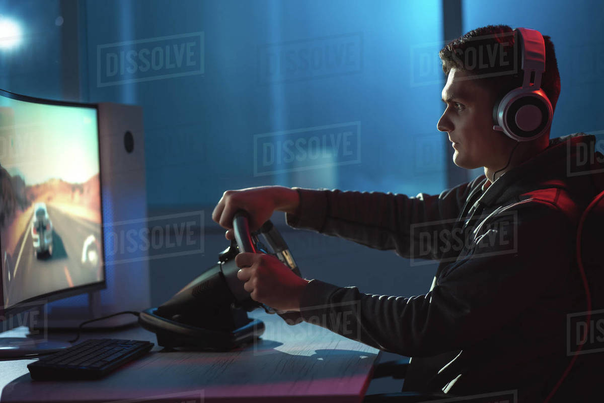 The guy gamer with headphones playing video game on his personal ...