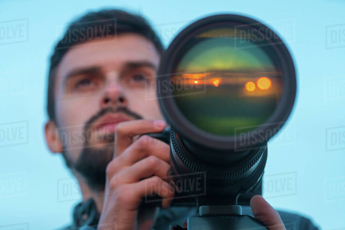The man work camera lens on the background of the sky - Stock Photo ...