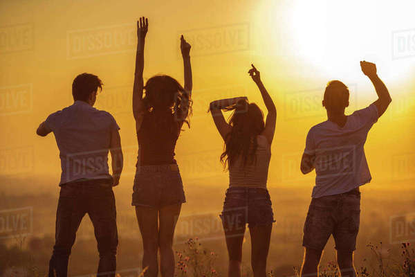 The four people dancing on the bright sun background - Royalty-free ...