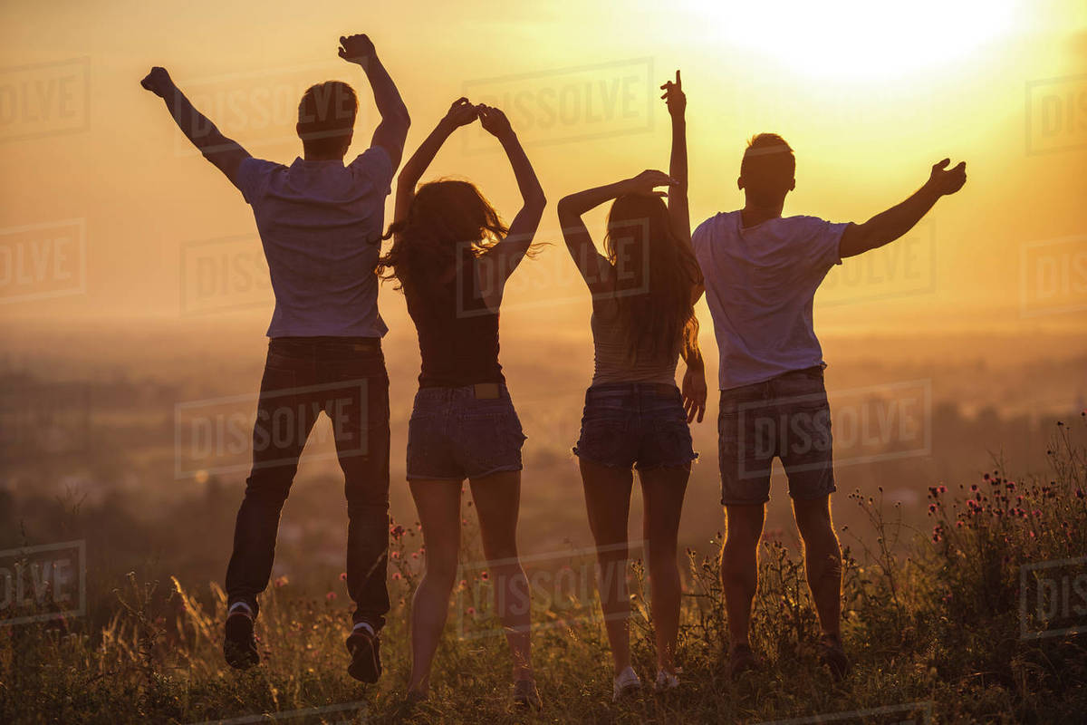 The four people jumping on the sunrise background - Royalty-free Stock ...