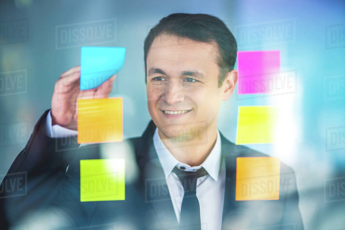 The businessman work with stickers on the window - Stock Photo - Dissolve