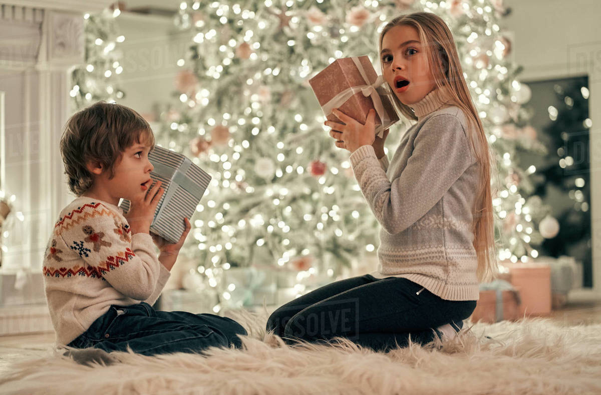 The surprised kids with gifts sitting on the floor - Royalty-free Stock ...