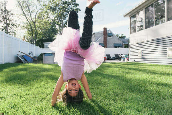 Girl in garden upside down doing handstand - Stock Photo - Dissolve
