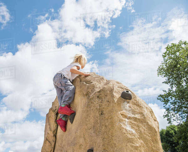 Boy climbing up climbing wall - Royalty-free Stock Photo | Dissolve