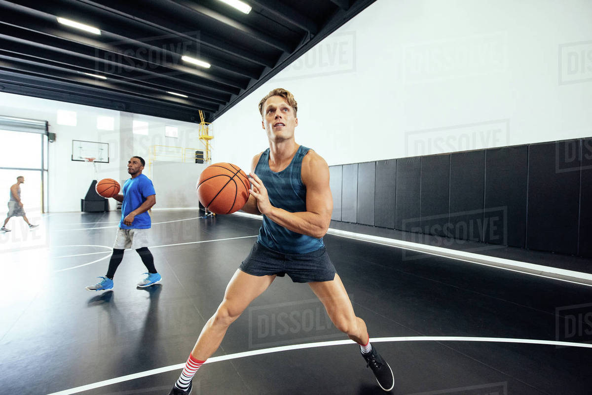 Male basketball player practicing aim on court - Stock Photo - Dissolve