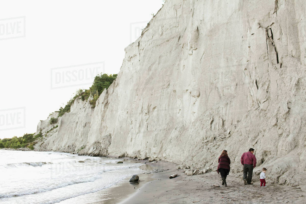 Family walking on beach by cliffs, Toronto, Ontario, Canada - Royalty ...