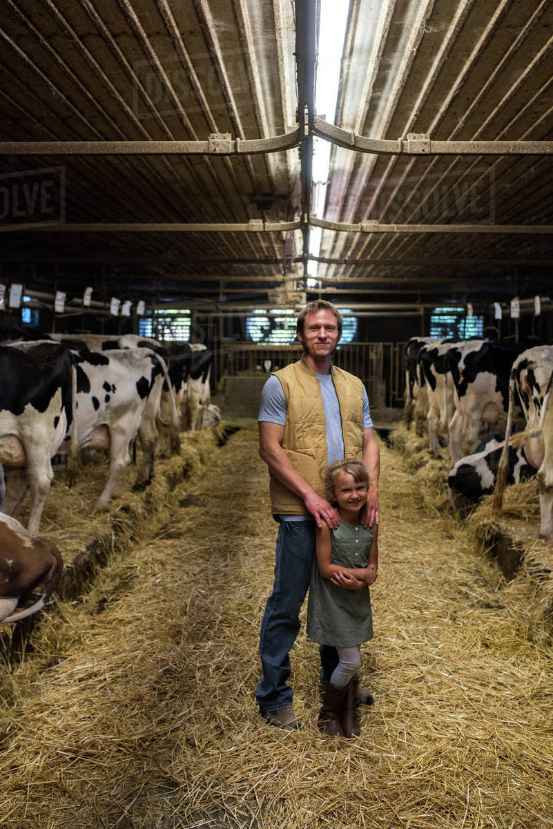 Portrait of farmer and daughter in cow shed - Royalty-free Stock Photo ...