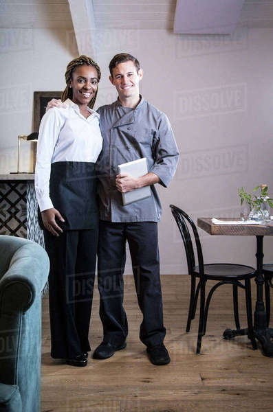 Portrait of male and female waiting staff in restaurant - Royalty-free ...