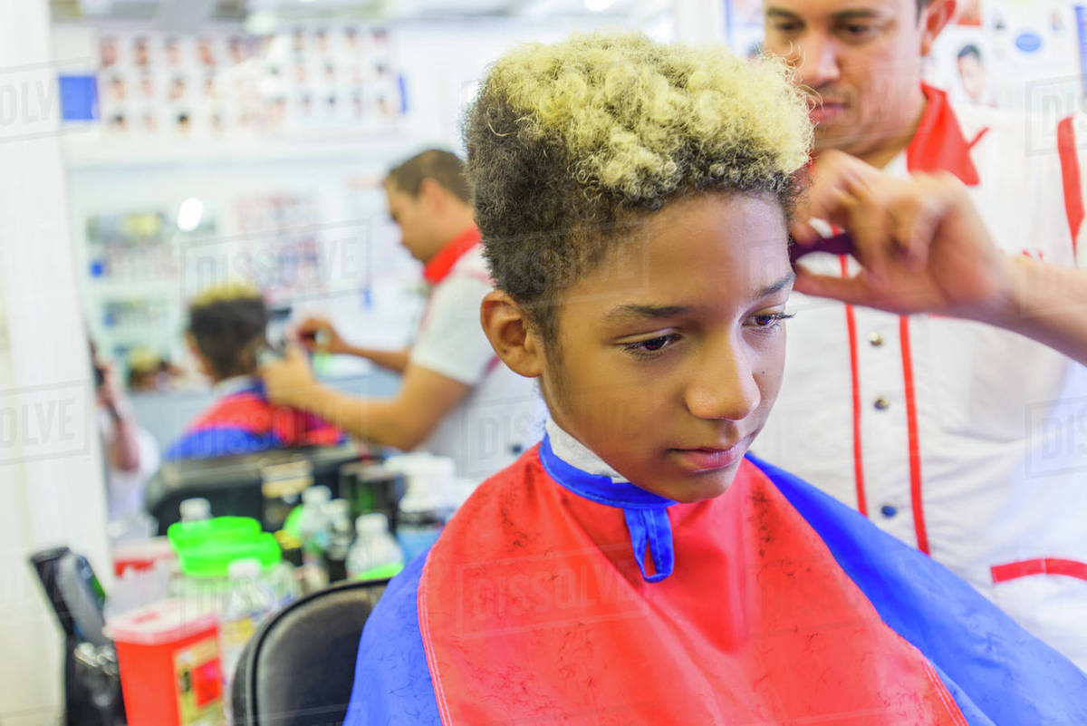 Hairdresser cutting teenage boy's hair in barbershop - Royalty-free ...