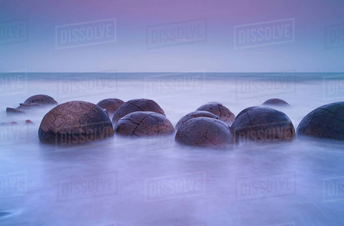 Waves washing over rocks on beach - Royalty-free Stock Photo | Dissolve