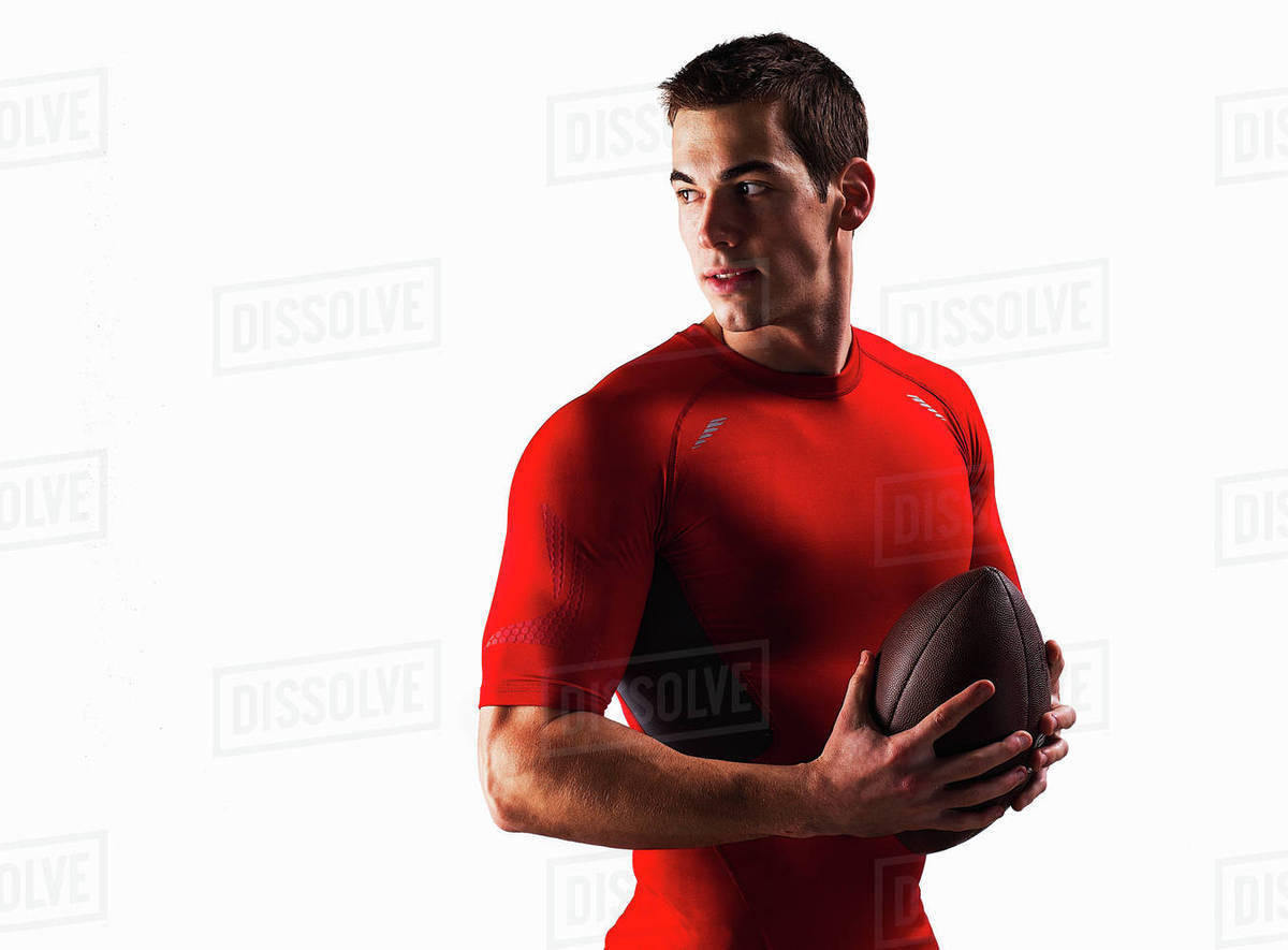 Athletic man holding football - Royalty-free Stock Photo | Dissolve