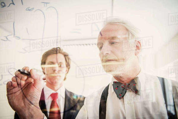Two men writing on transparent wipe board - Royalty-free Stock Photo ...