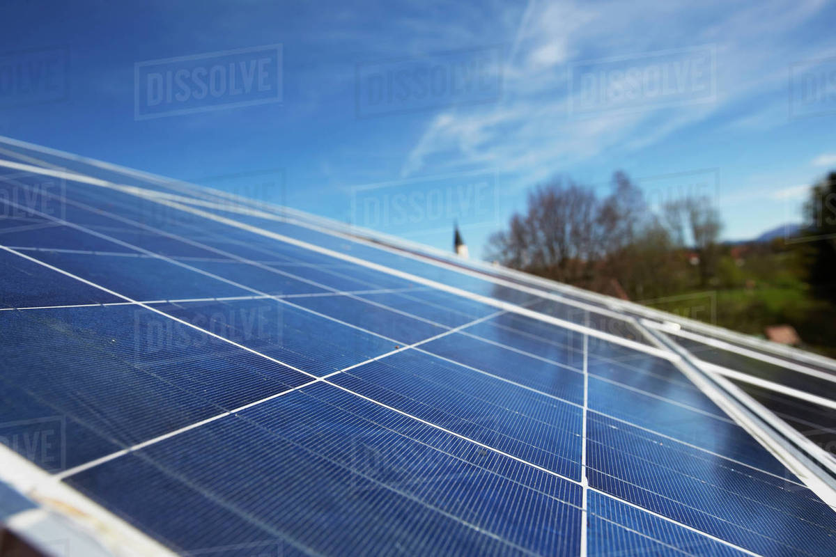 Elevated close up of solar panels on house roof and blue sky - Royalty ...